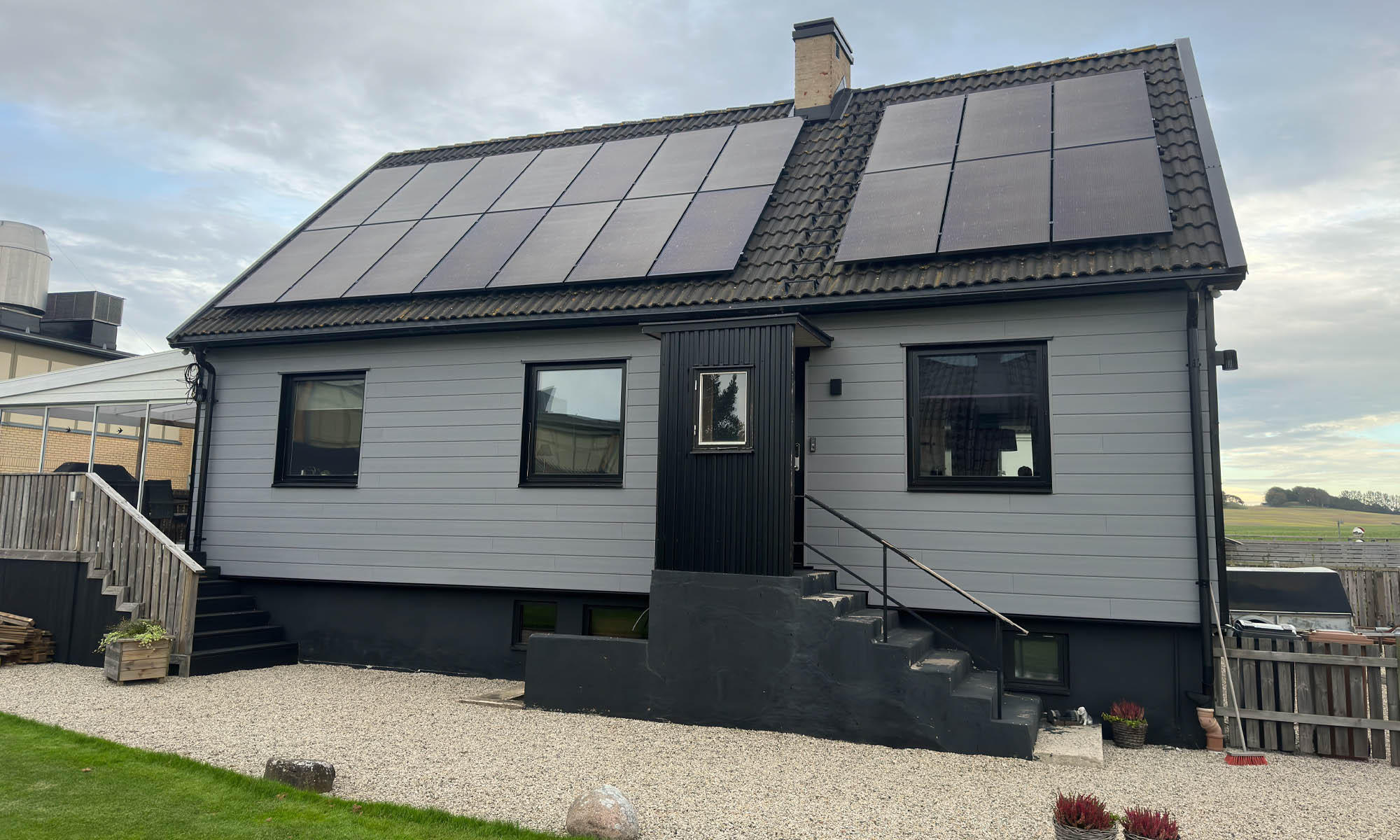 Ljusgrå fasad och svart tak. Sverigepanelen i stormgrå